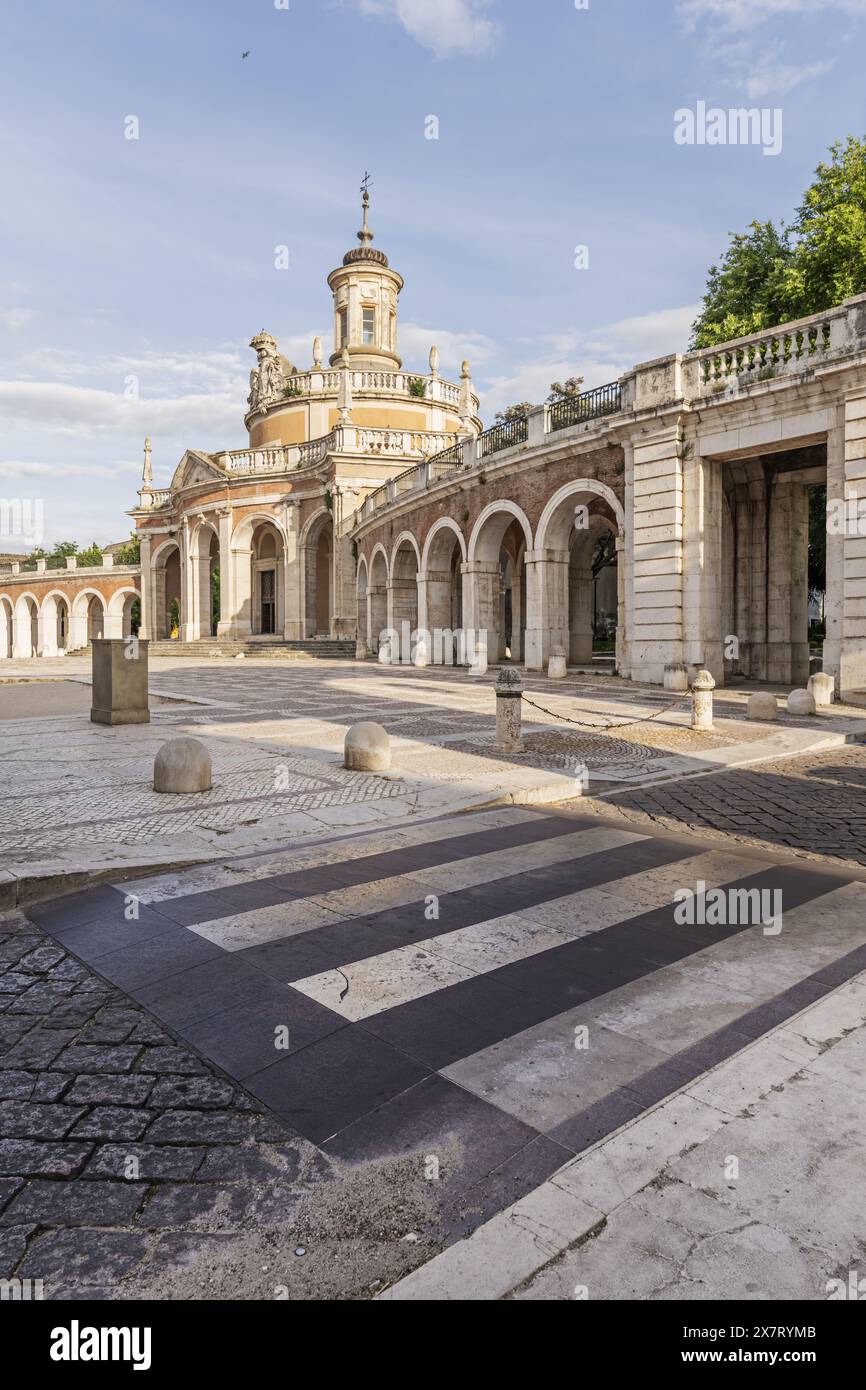 A cobbled path with zebra crossing in an old building area with arches ...