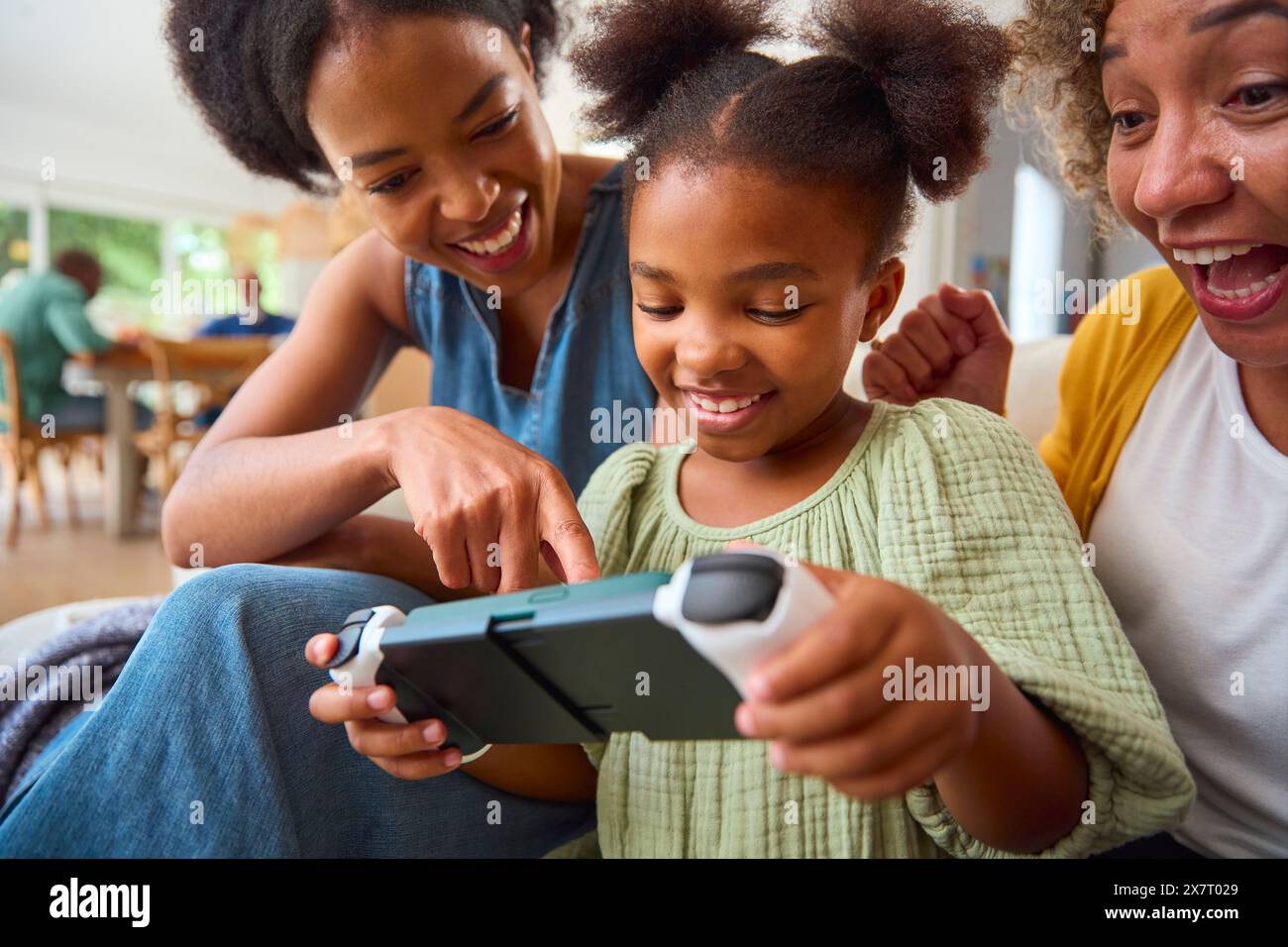 Grandmother With Mother And Granddaughter Playing With Handheld Gaming ...