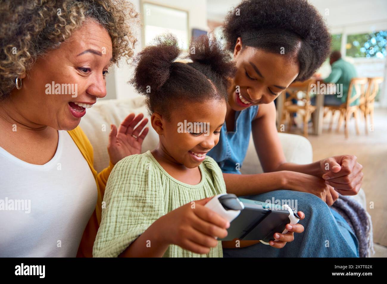 Grandmother With Mother And Granddaughter Playing With Handheld Gaming ...