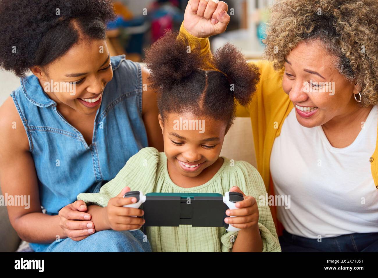 Grandmother With Mother And Granddaughter Playing With Handheld Gaming ...
