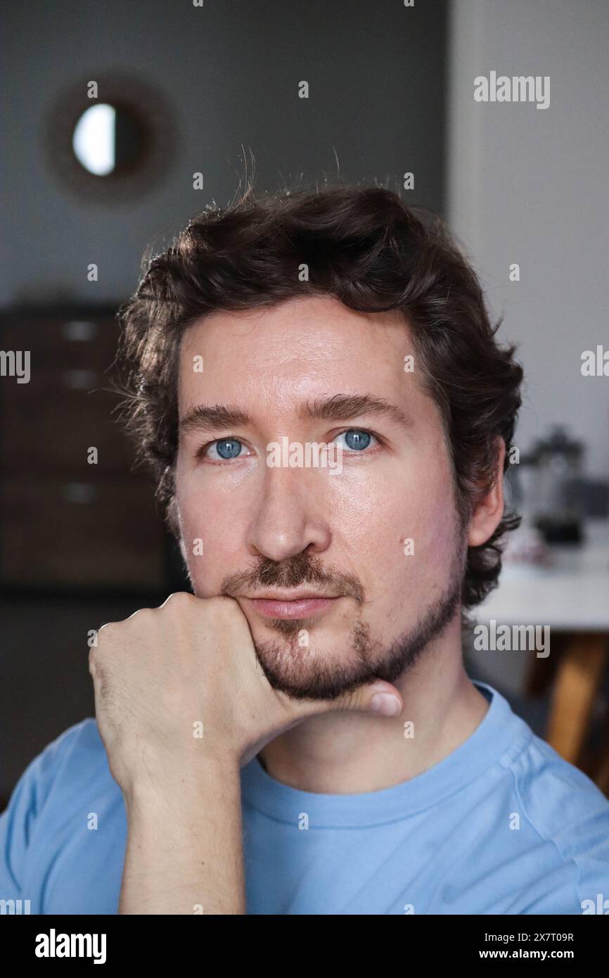 Handsome young man with blue eyes and curly wavy hair Stock Photo - Alamy