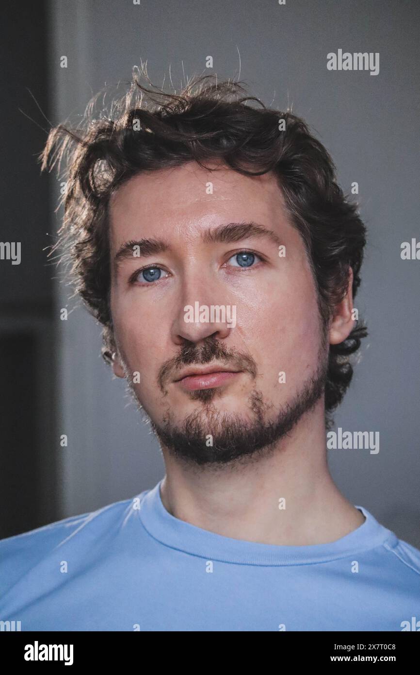 Handsome young man with blue eyes and curly wavy hair Stock Photo - Alamy
