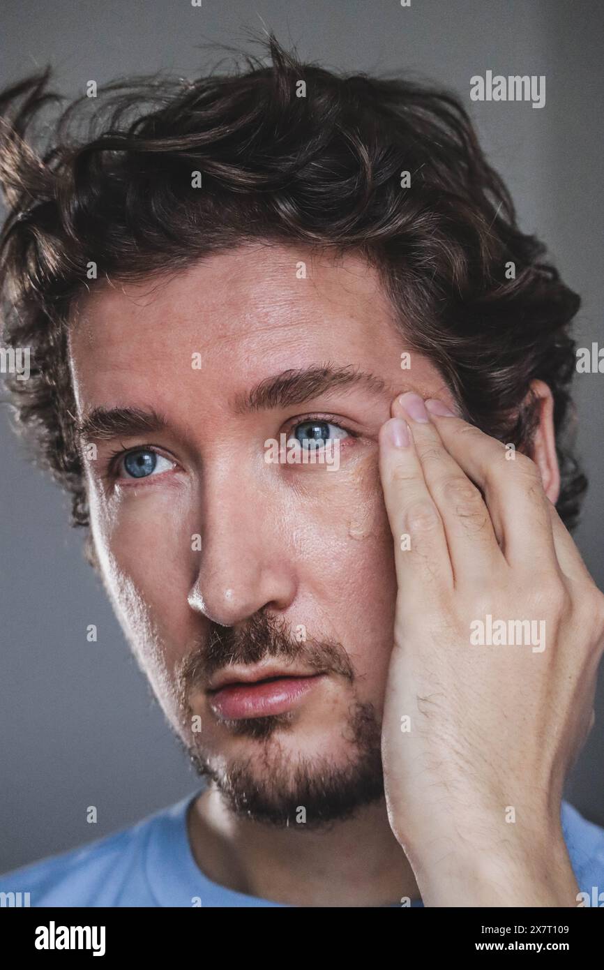 Handsome young man applying foundation to his face Stock Photo - Alamy