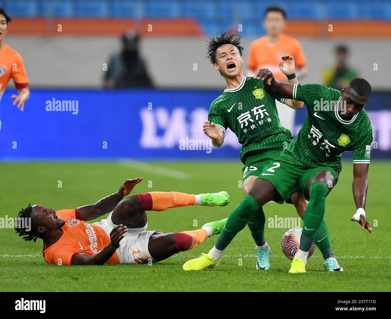 Qingdao, China's Shandong Province. 21st May, 2024. Jiang Wenhao (C) of Beijing Guoan vies with ...