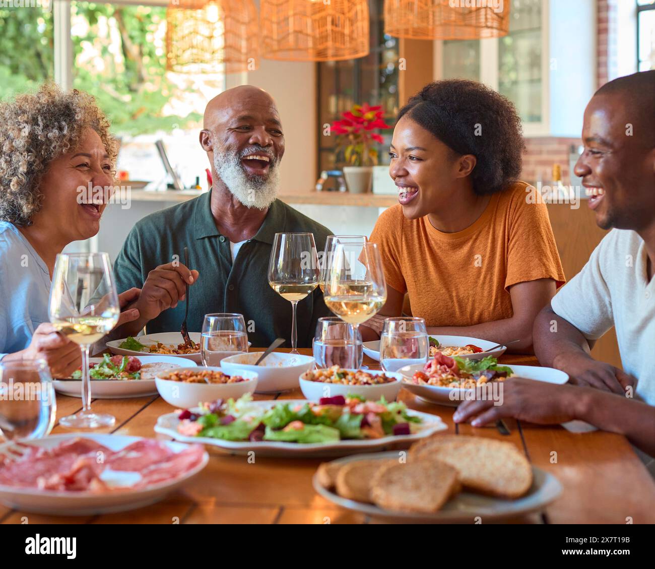 Senior Parents Around Table Eating Meal With Wine At Home With Adult ...