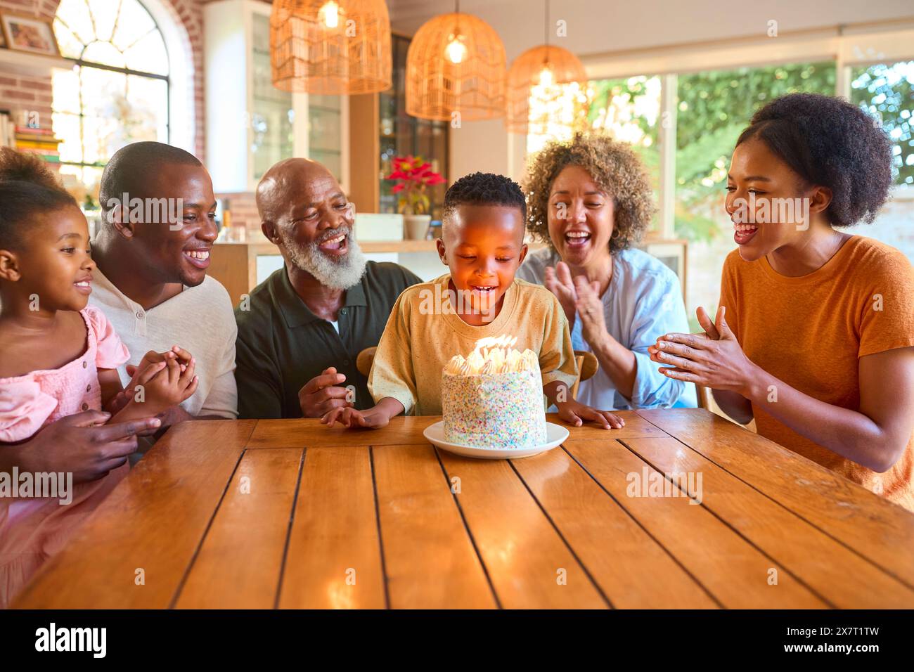 Multi-Generation Family Celebrating Grandson's Birthday At Home Blowing ...
