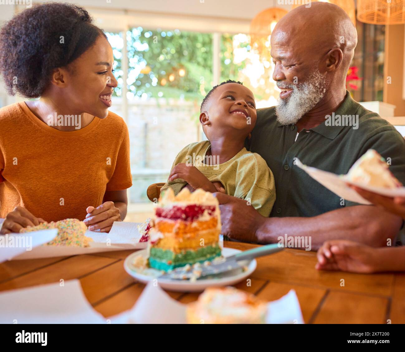 Multi-Generation Family Celebrating Grandson's Birthday At Home Blowing ...