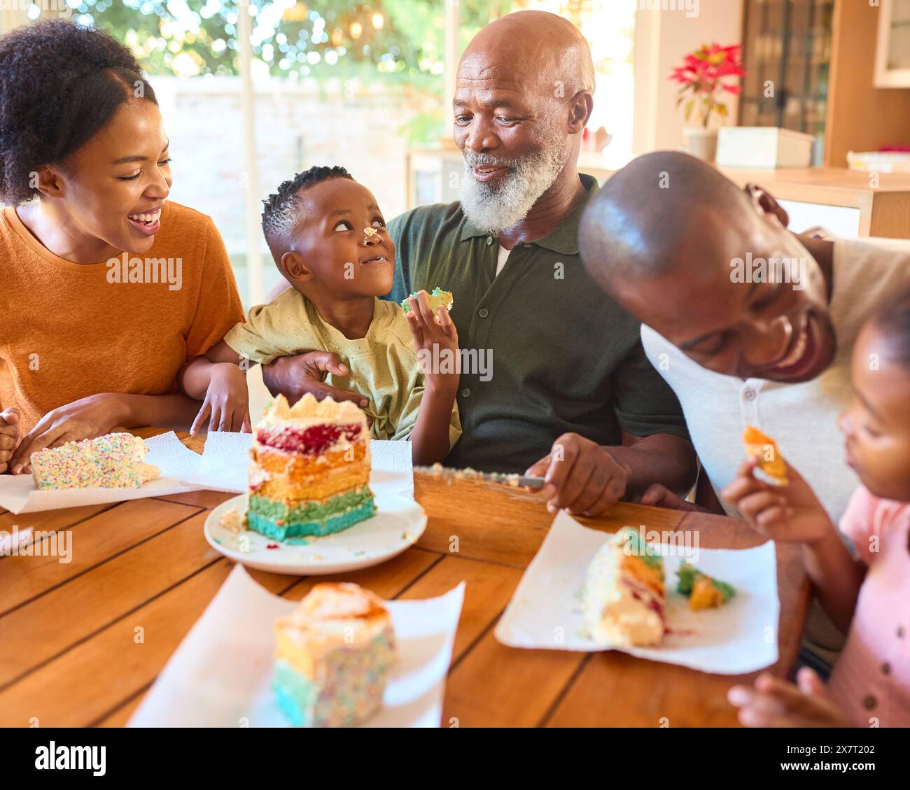 Multi-Generation Family Celebrating Grandson's Birthday At Home Blowing ...