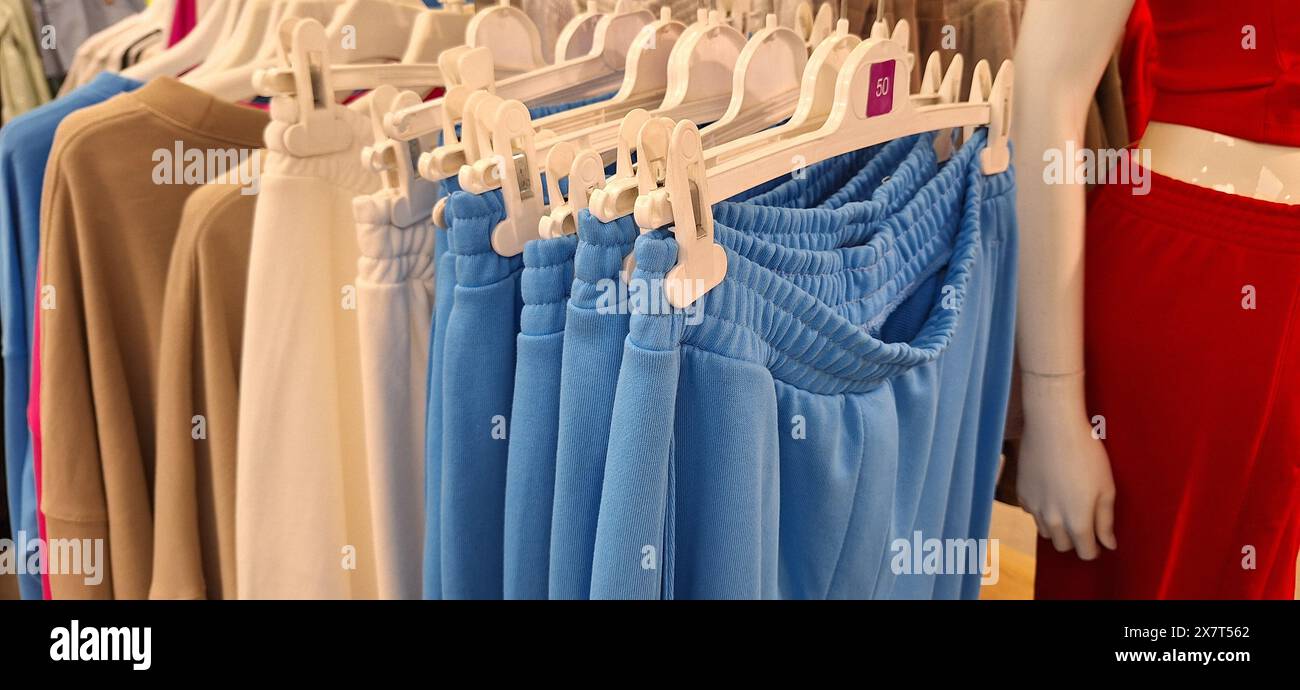 A retail store features a neatly organized clothing rack displaying ...