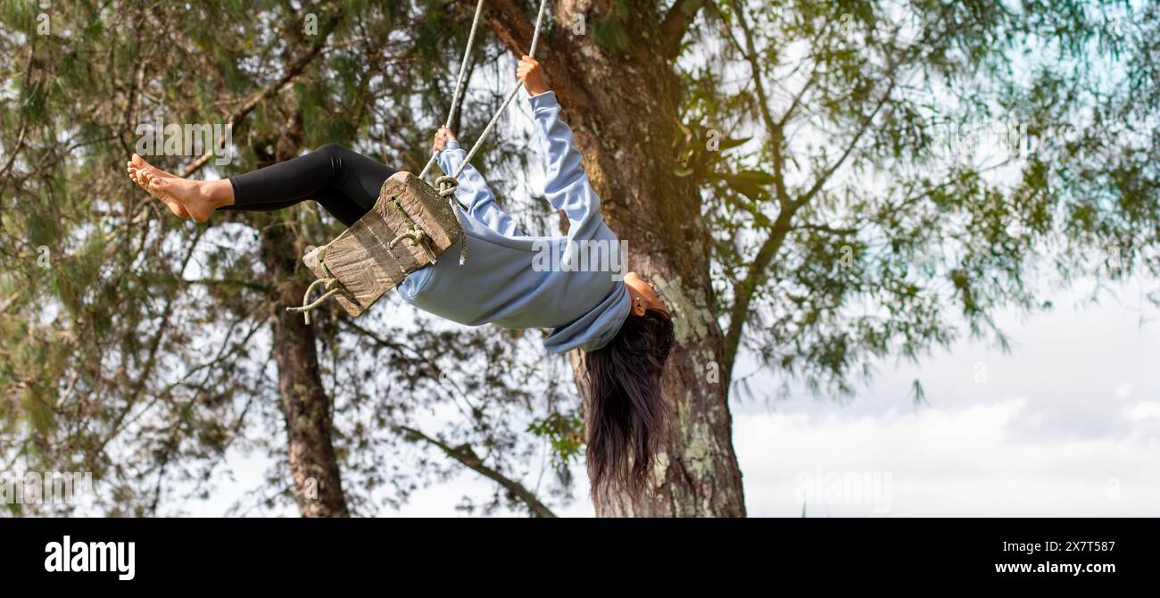lifestyle: latina woman swings on a swing in a tree Stock Photo - Alamy