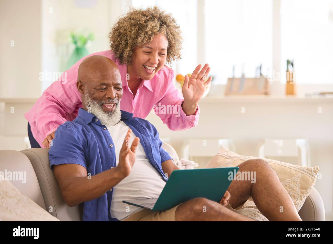 Mature Couple At Home With Laptop Making Video Call To Family Stock ...