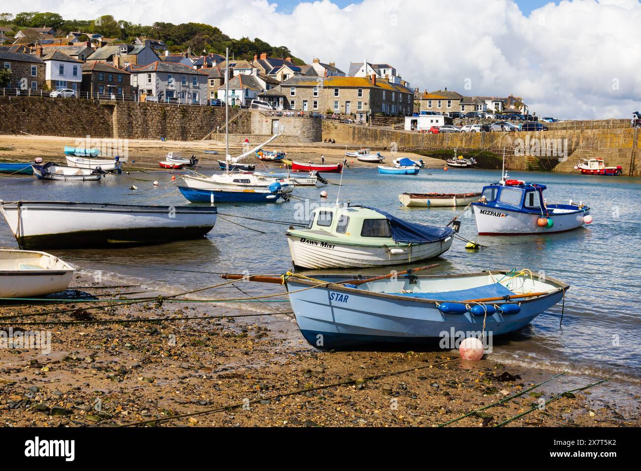 Boats in the harbour at mid tide, beach and mooring chains. The ...