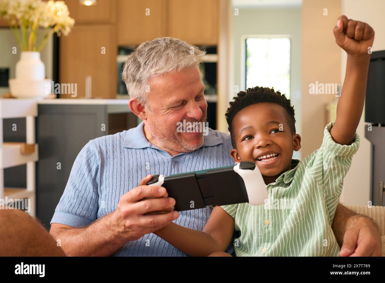 Multi Racial Family With Grandfather And Grandson Playing On Handheld ...