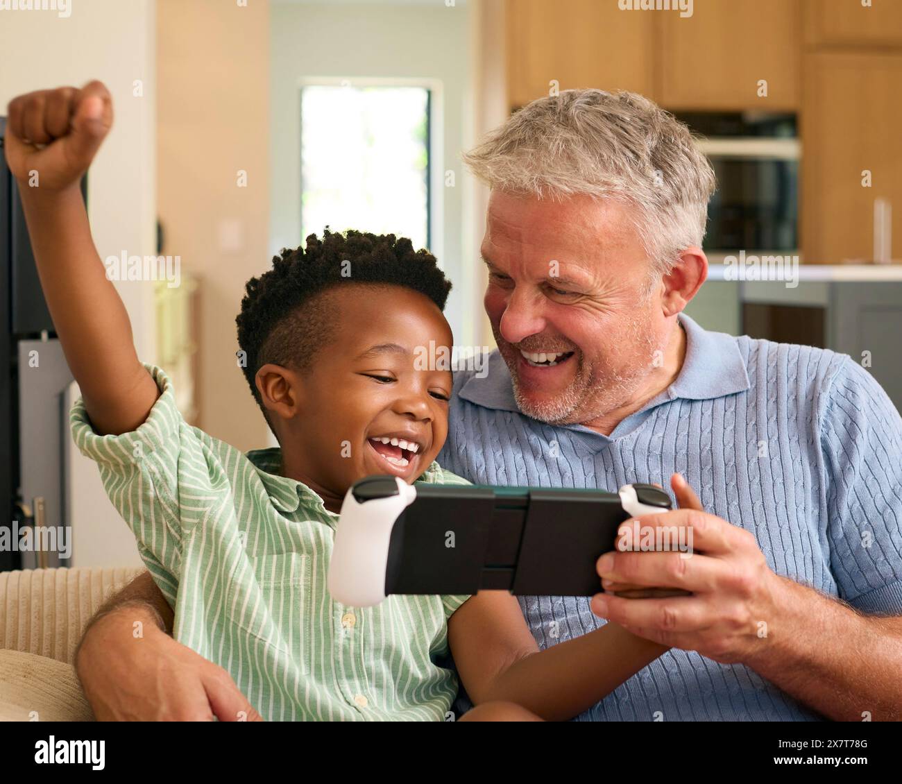 Multi Racial Family With Grandfather And Grandson Playing On Handheld ...
