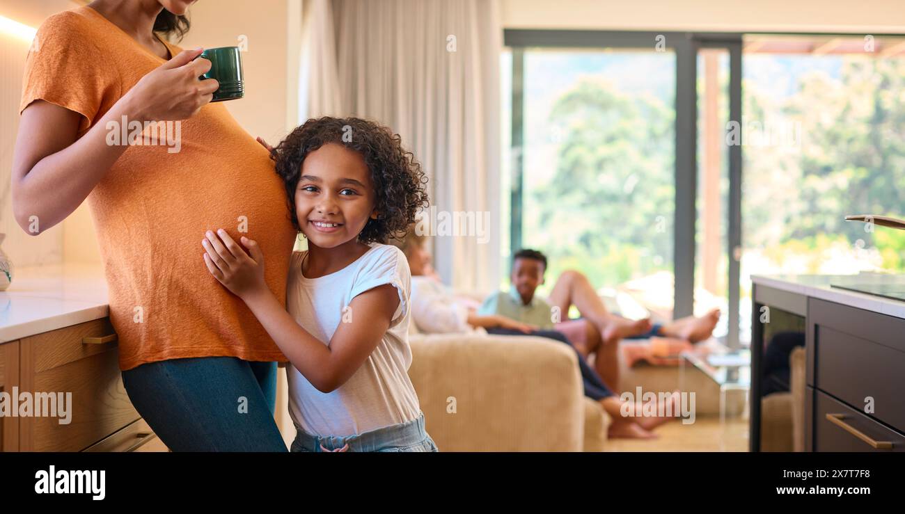 Multi Generation Family At Home As Daughter Listens To Baby's Heartbeat ...