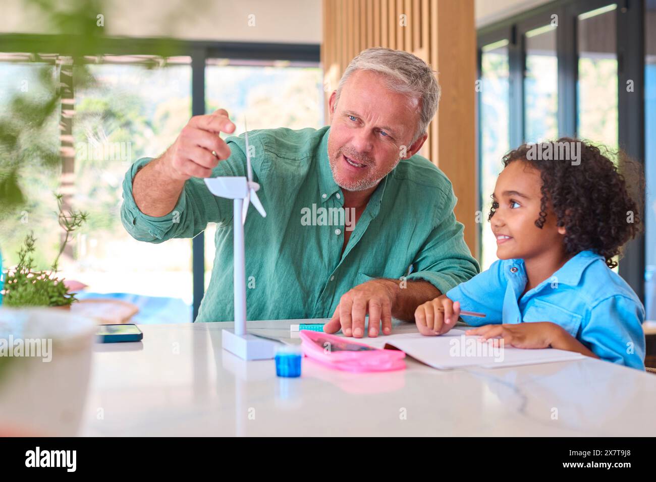 Family With Grandfather And Granddaughter Doing Homework On Green ...