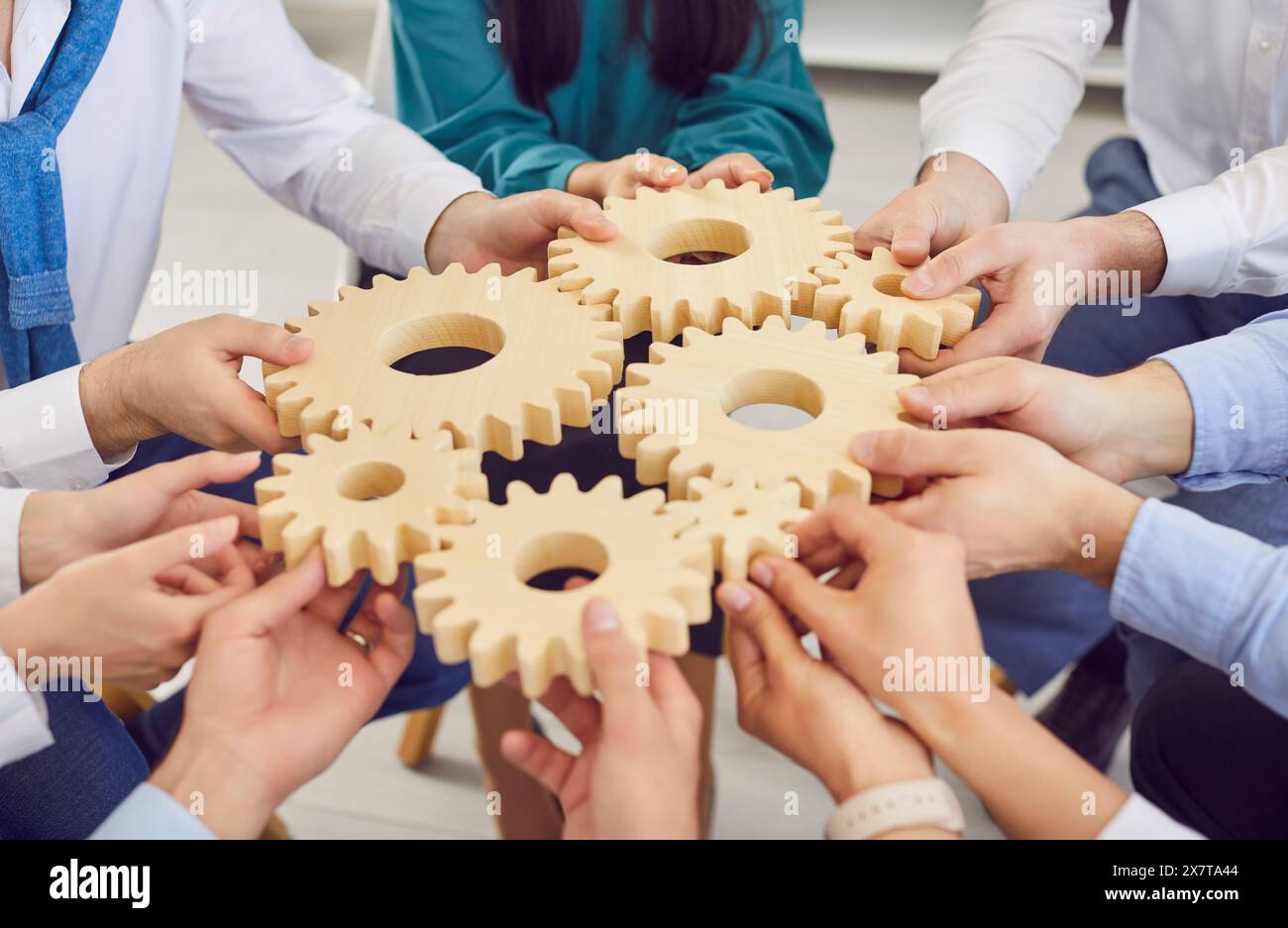 Group of business people connecting wooden gears together. Cooperation ...