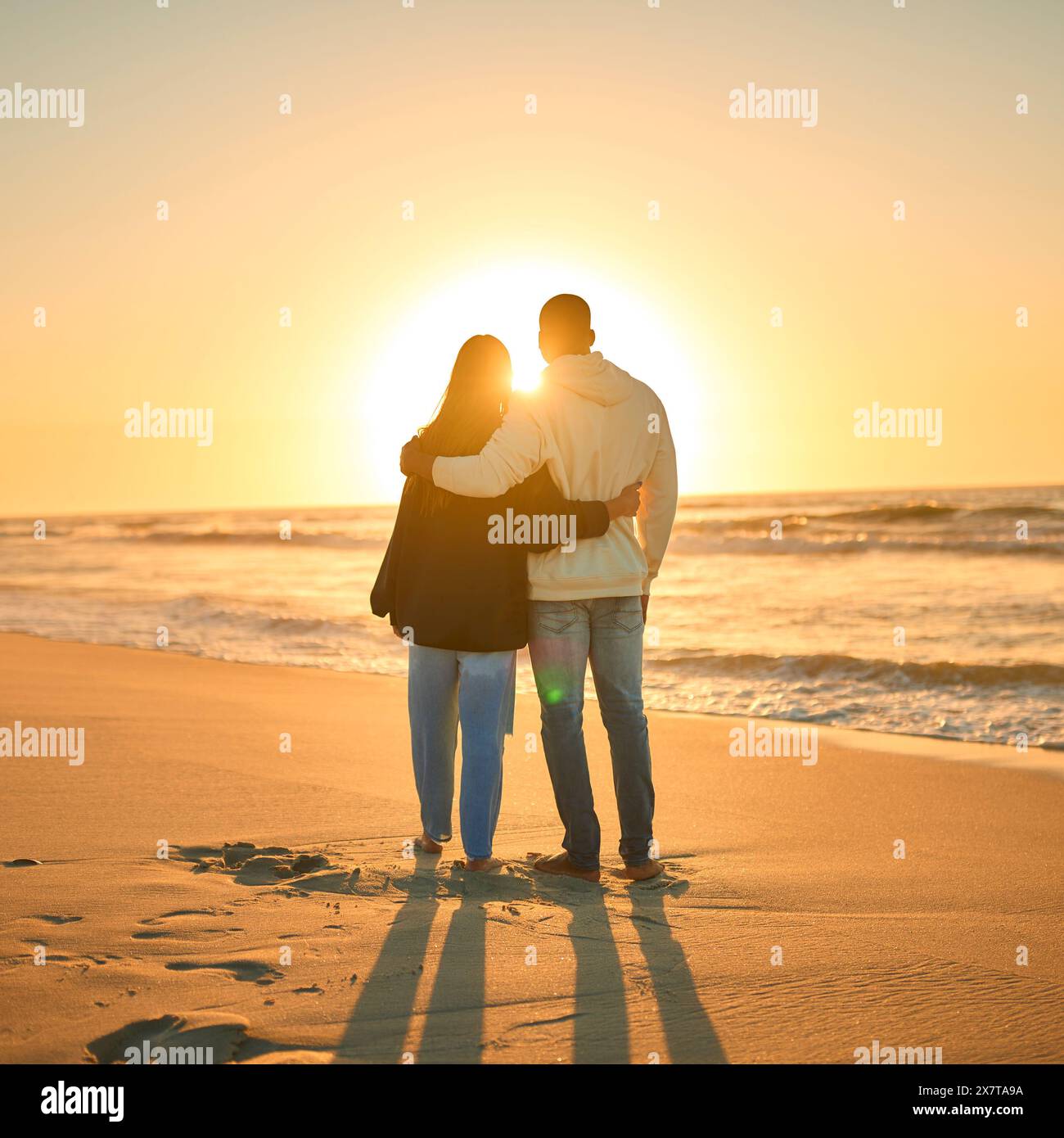Rear View Of Casually Dressed Loving Young Couple Standing On Beach