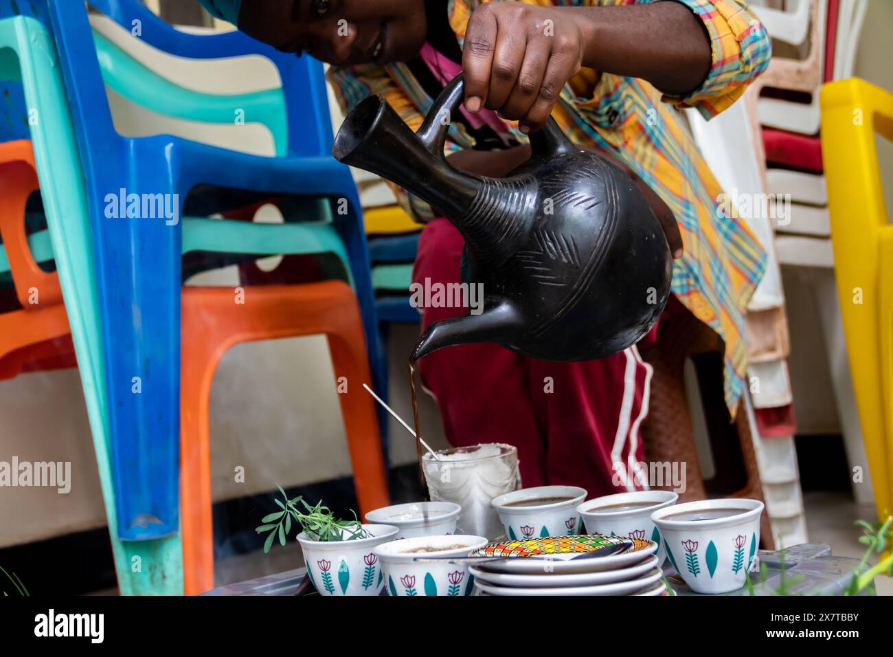 Freshly roasted coffee beans, a mortar and pestle with jebena, and incense smoke create a ...