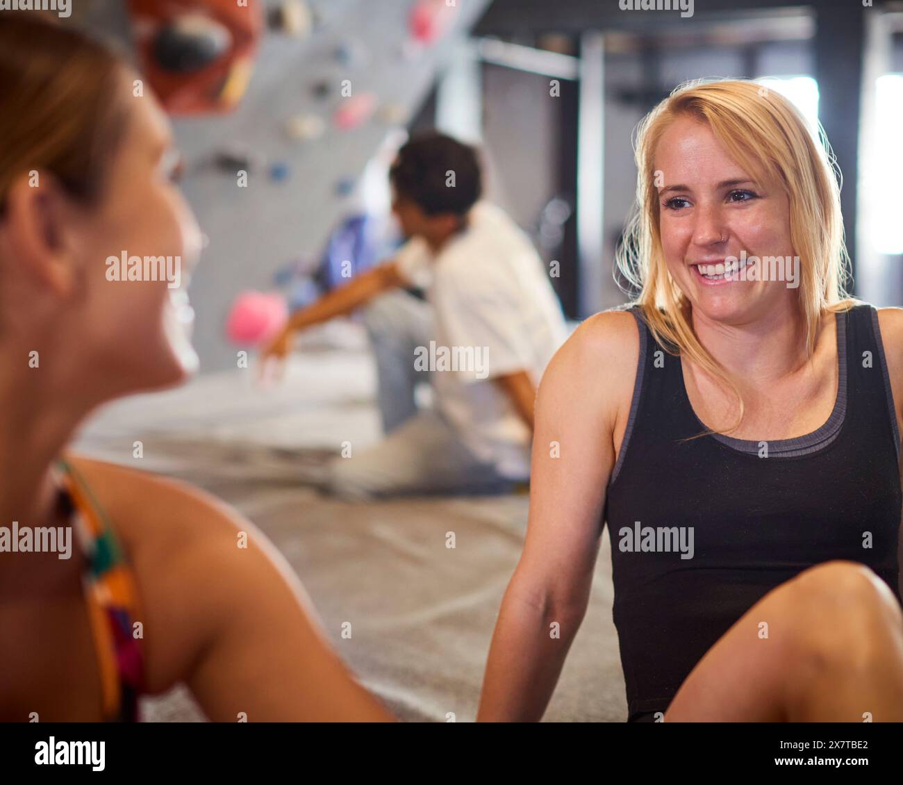 Close Up Of Two Women Taking A Break And Talking By Climbing Wall In ...