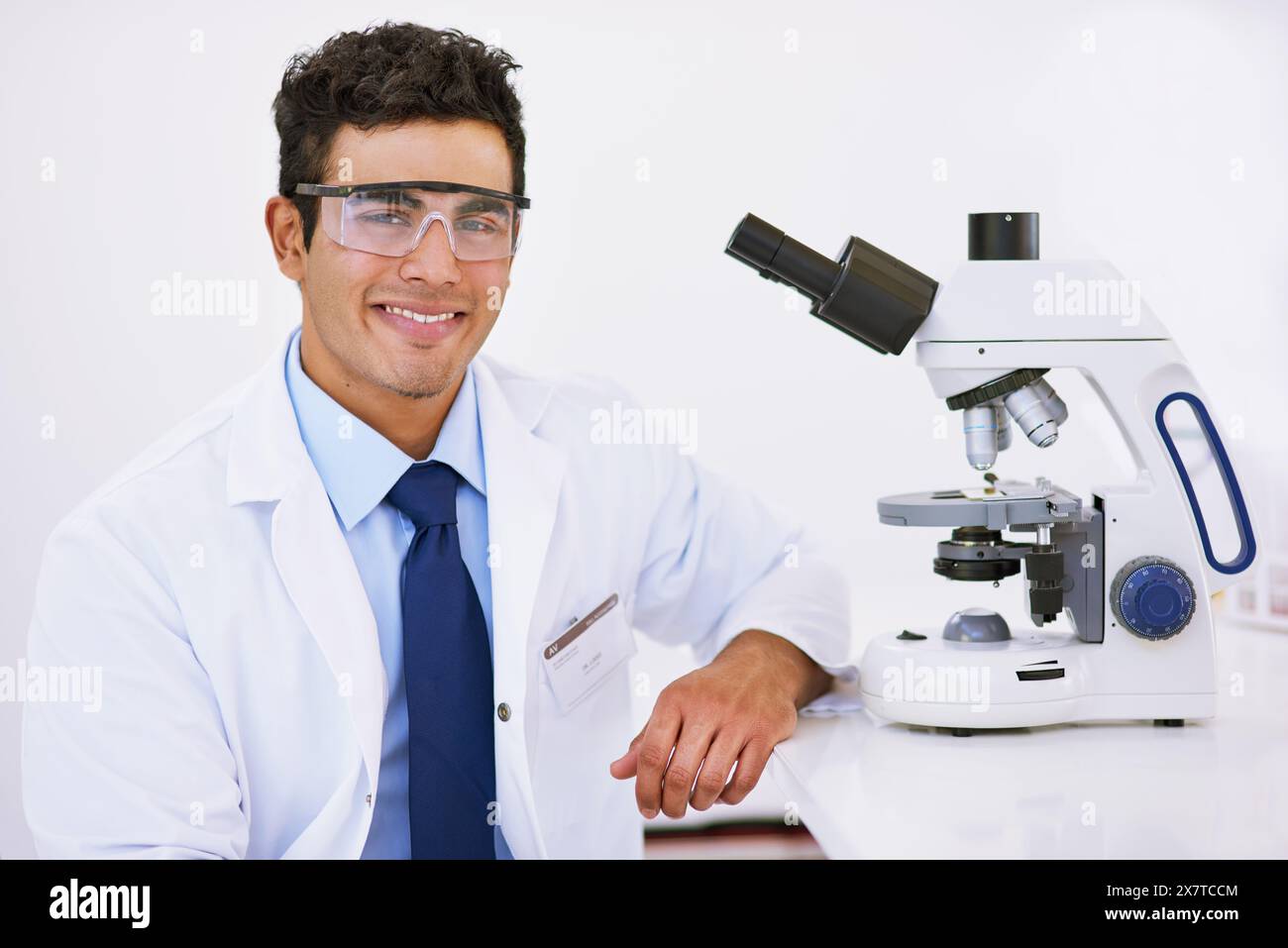 Scientist, man and microscope in portrait with smile, safety goggles ...