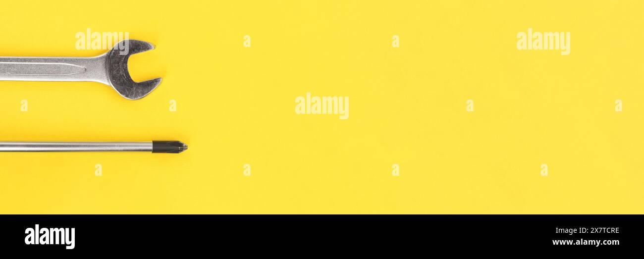 Work tools, wrench and screwdriver on bright yellow background banner ...