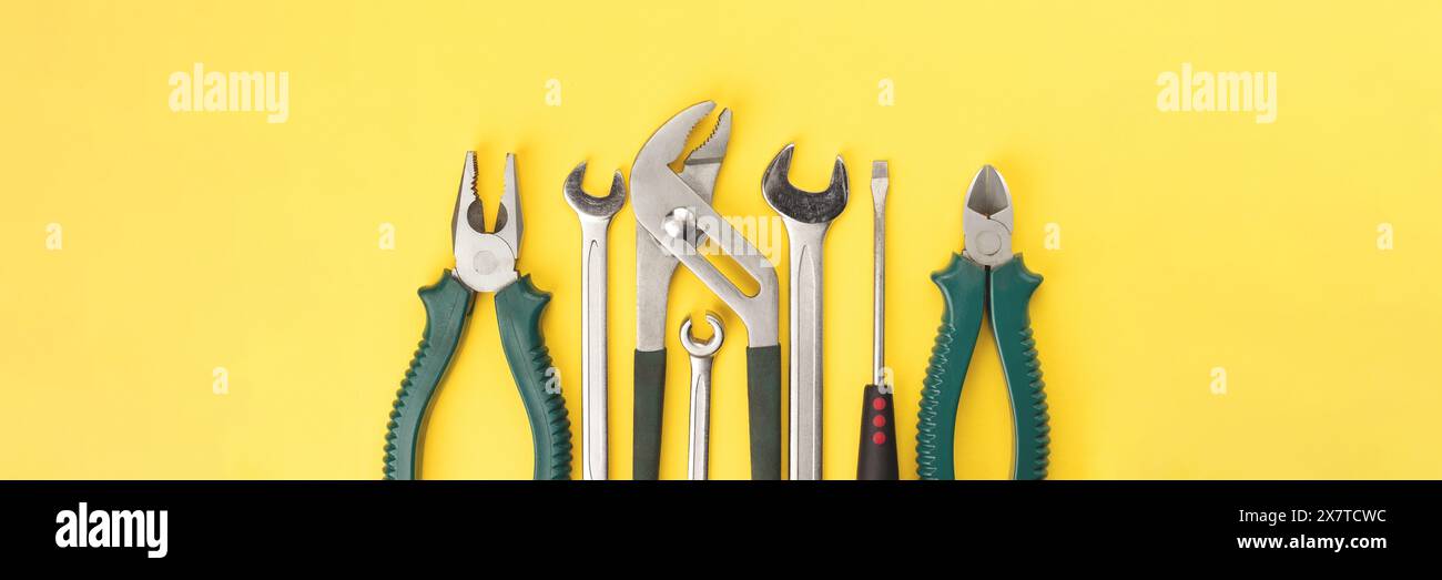 Work tools on bright yellow background banner. Panoramic web header ...