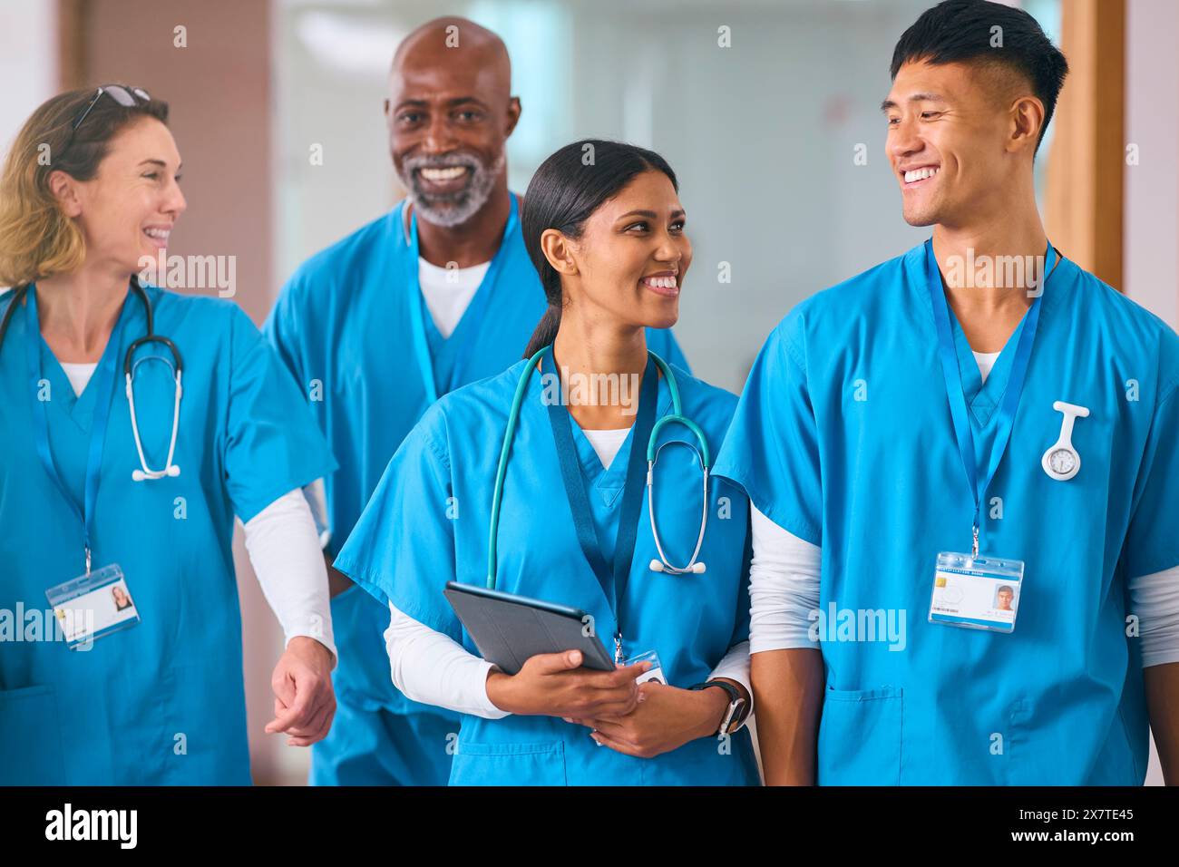 Smiling Multi Cultural Medical Team Wearing Scrubs Talking In Modern ...
