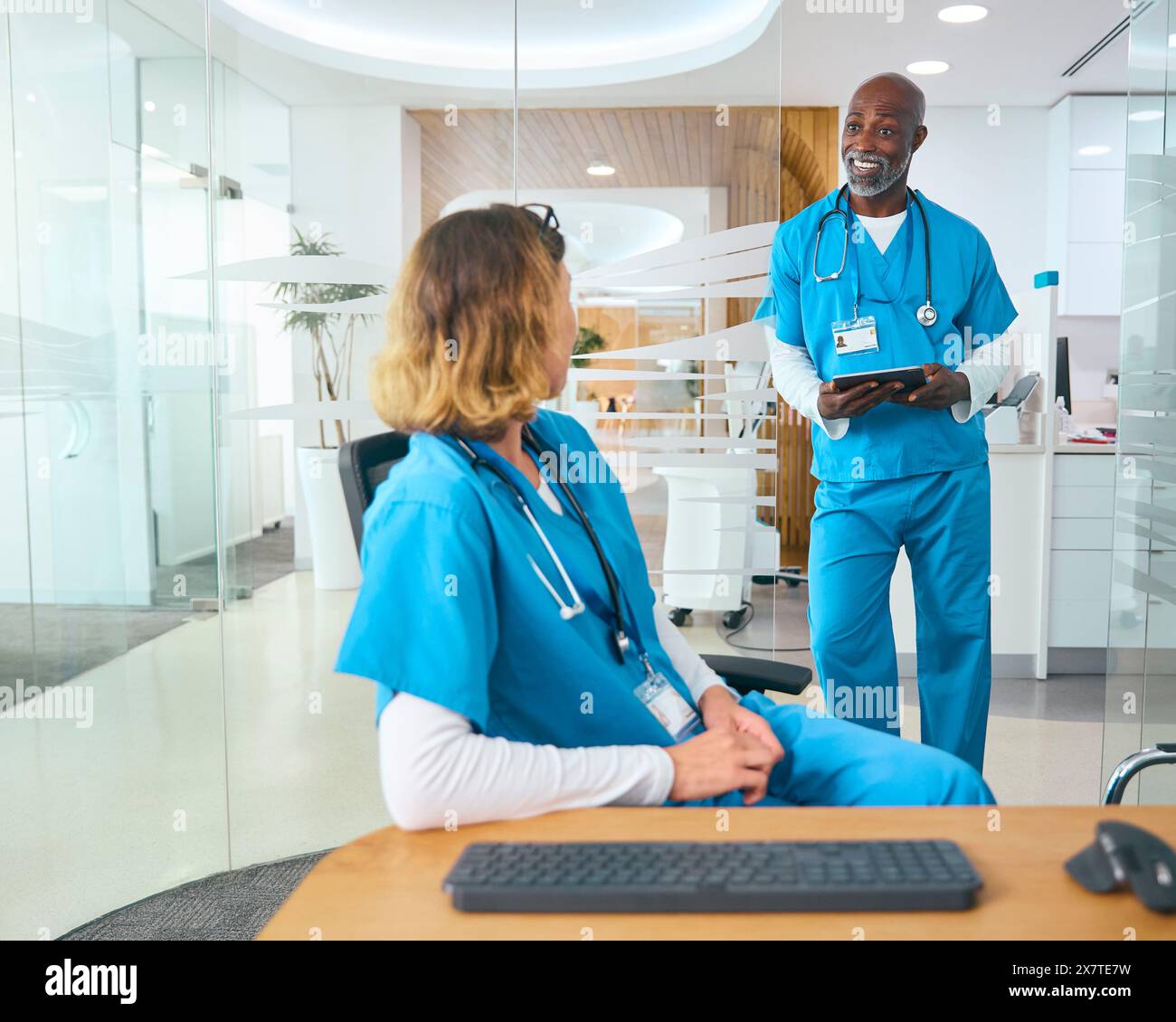 Male And Female Doctors Wearing Scrubs Having Informal Meeting In ...