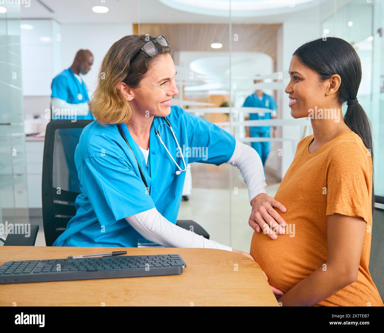 Female Nurse Or Doctor Wearing Scrubs Examining Pregnant Woman In ...