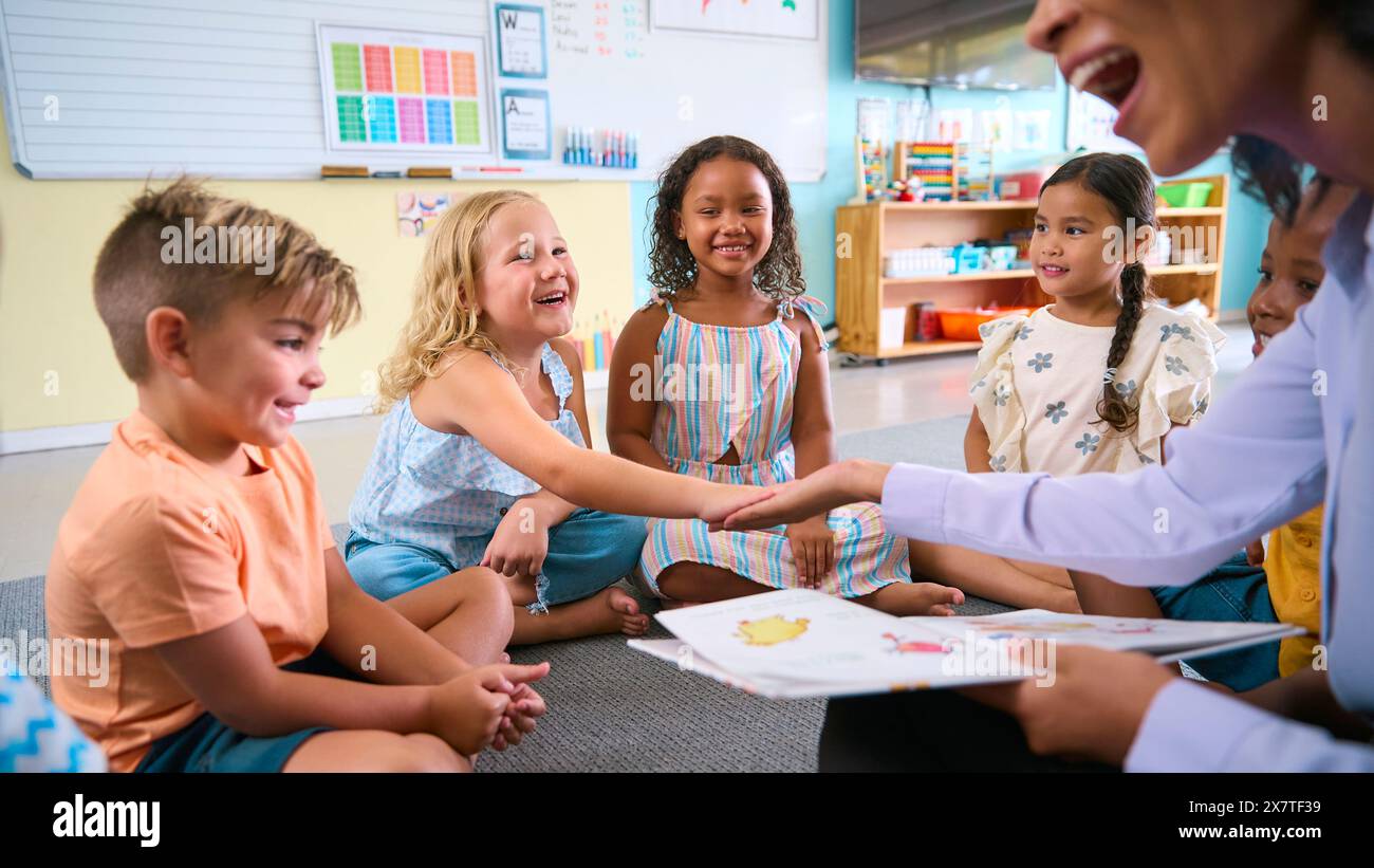 Female Primary Or Elementary School Teacher Gives Student High Five In ...