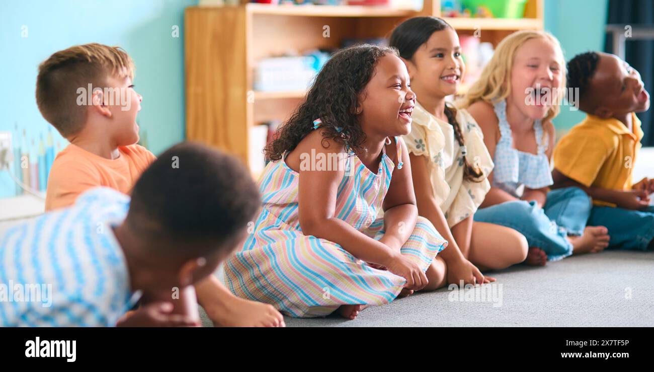 Line Of Smiling Primary Or Elementary School Students Sitting On Floor ...