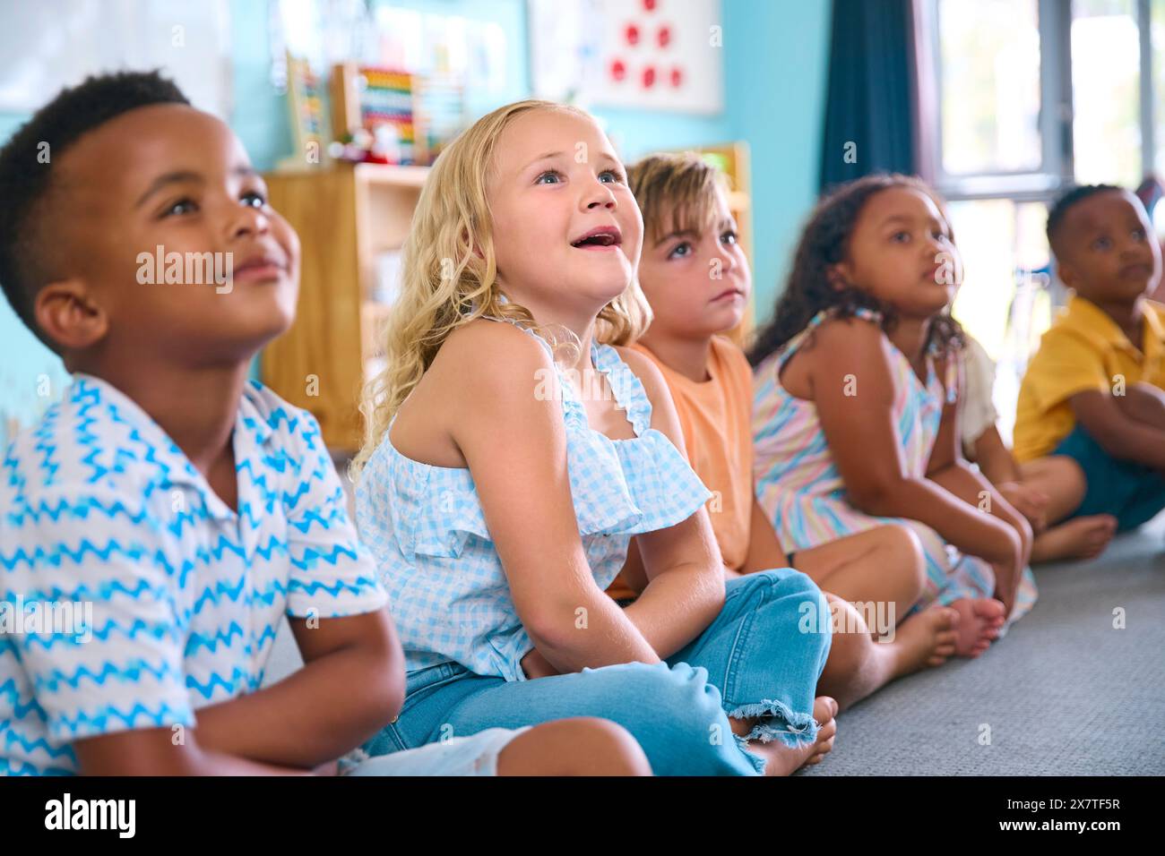 Line Of Smiling Primary Or Elementary School Students Sitting On Floor ...