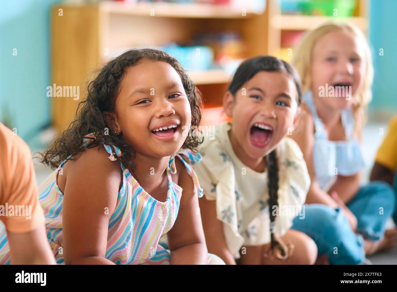 Line Of Smiling Primary Or Elementary School Students Sitting On Floor ...