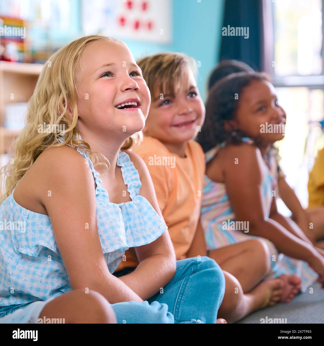 Line Of Smiling Primary Or Elementary School Students Sitting On Floor ...