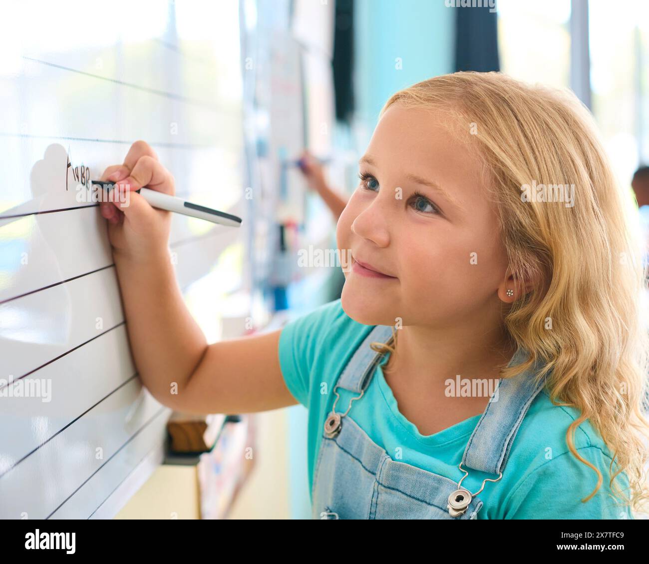 Female Primary Or Elementary School Student Writing On Whiteboard In ...