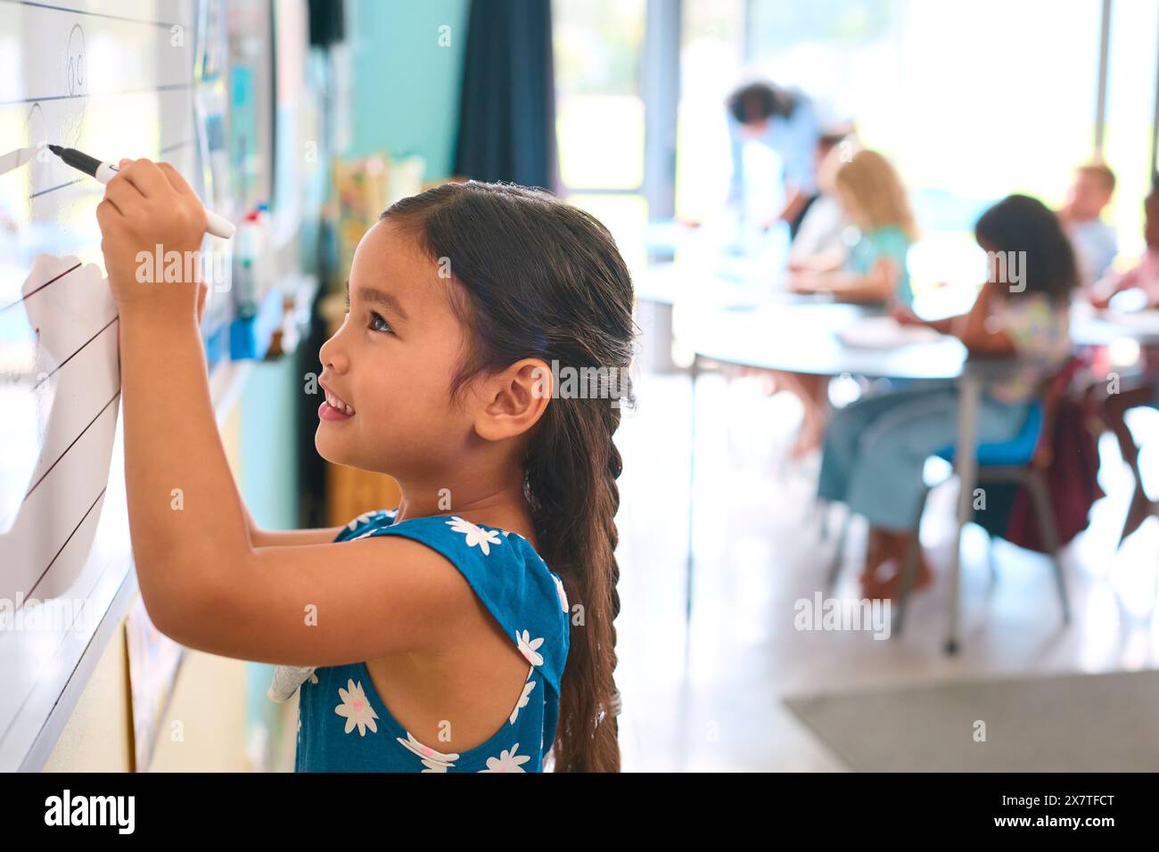 Female Primary Or Elementary School Student Writing On Whiteboard In ...
