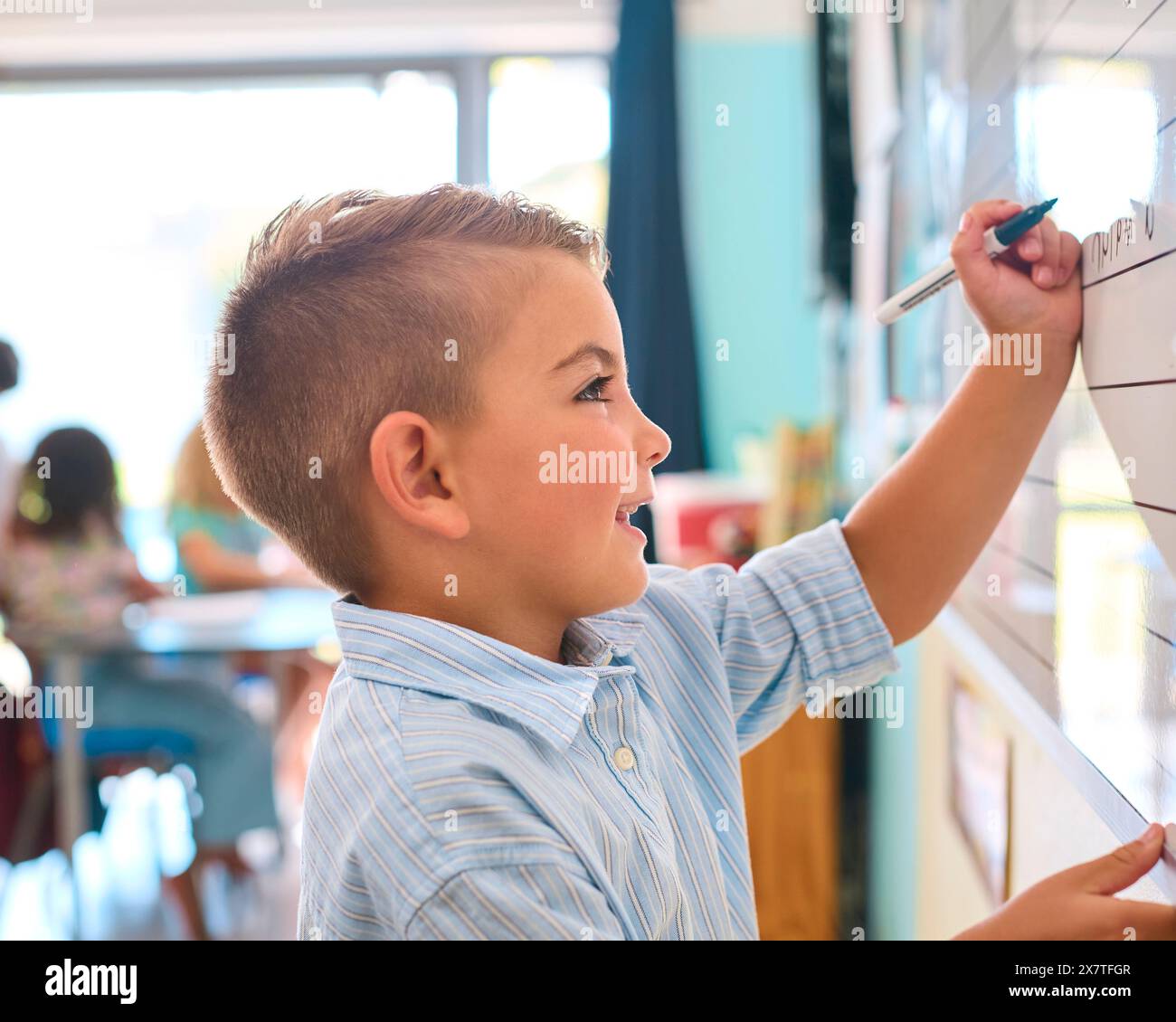Male Primary Or Elementary School Student Writing On Whiteboard In ...