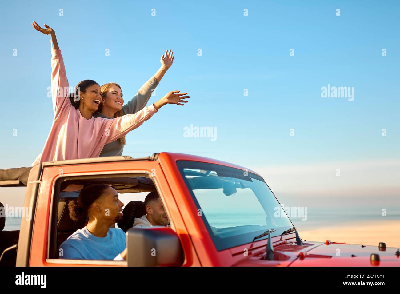 Couple With Friends On Vacation Driving Car On Road Trip Adventure To ...