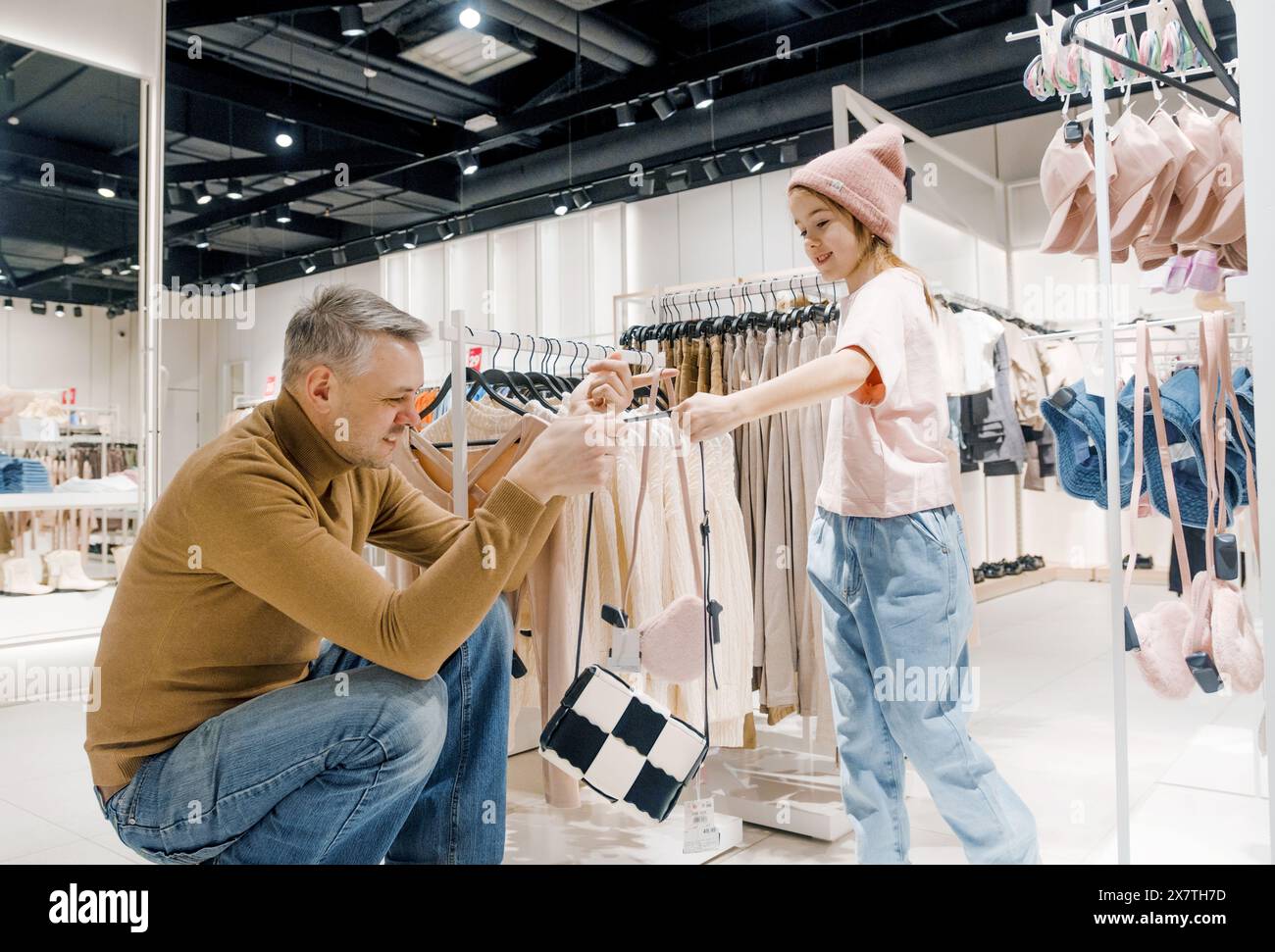 A father and daughter are browsing and examining items in a modern ...