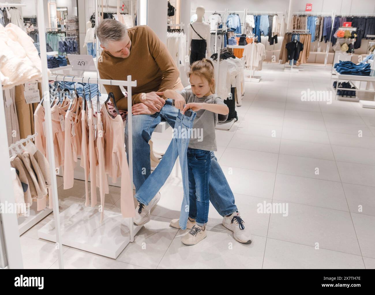 Father and Daughter Shopping for Clothes in a Modern Retail Store on a ...