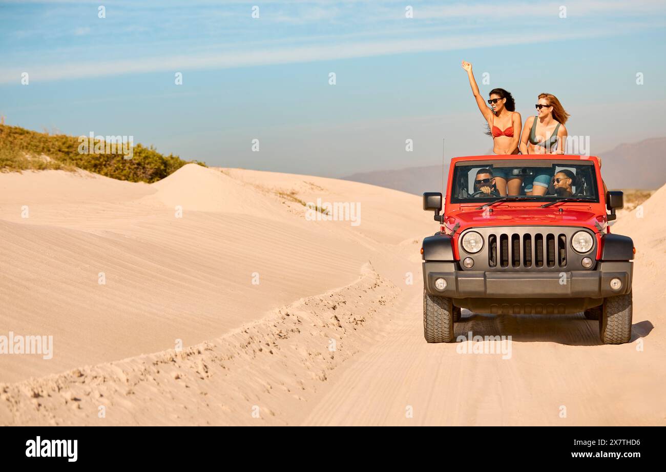 Couple With Friends On Vacation Driving Car On Road Trip Adventure To ...