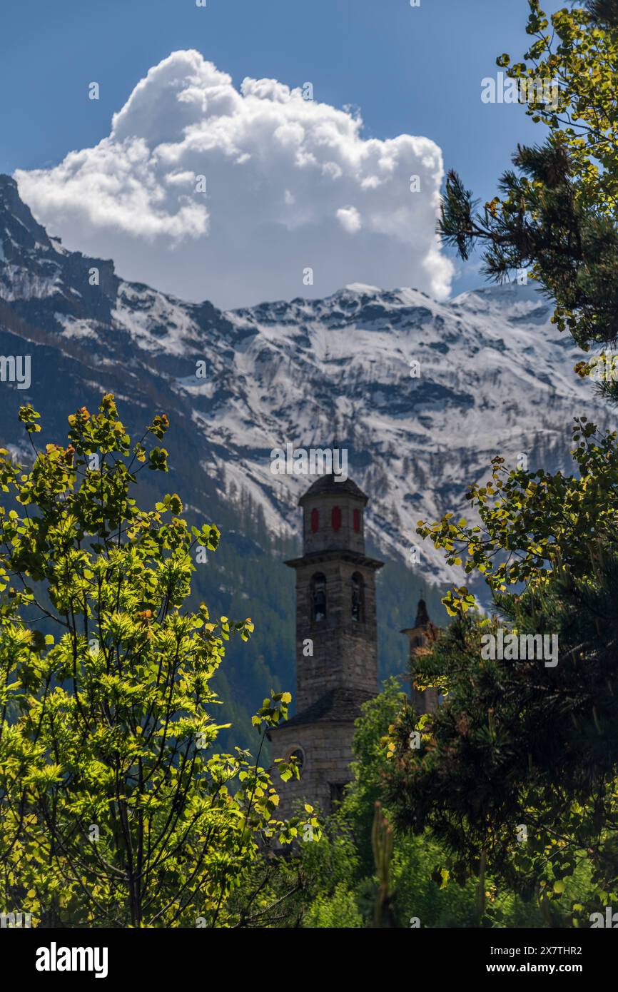 Bell tower and church with village in spring sunny day over Varzo Italy ...
