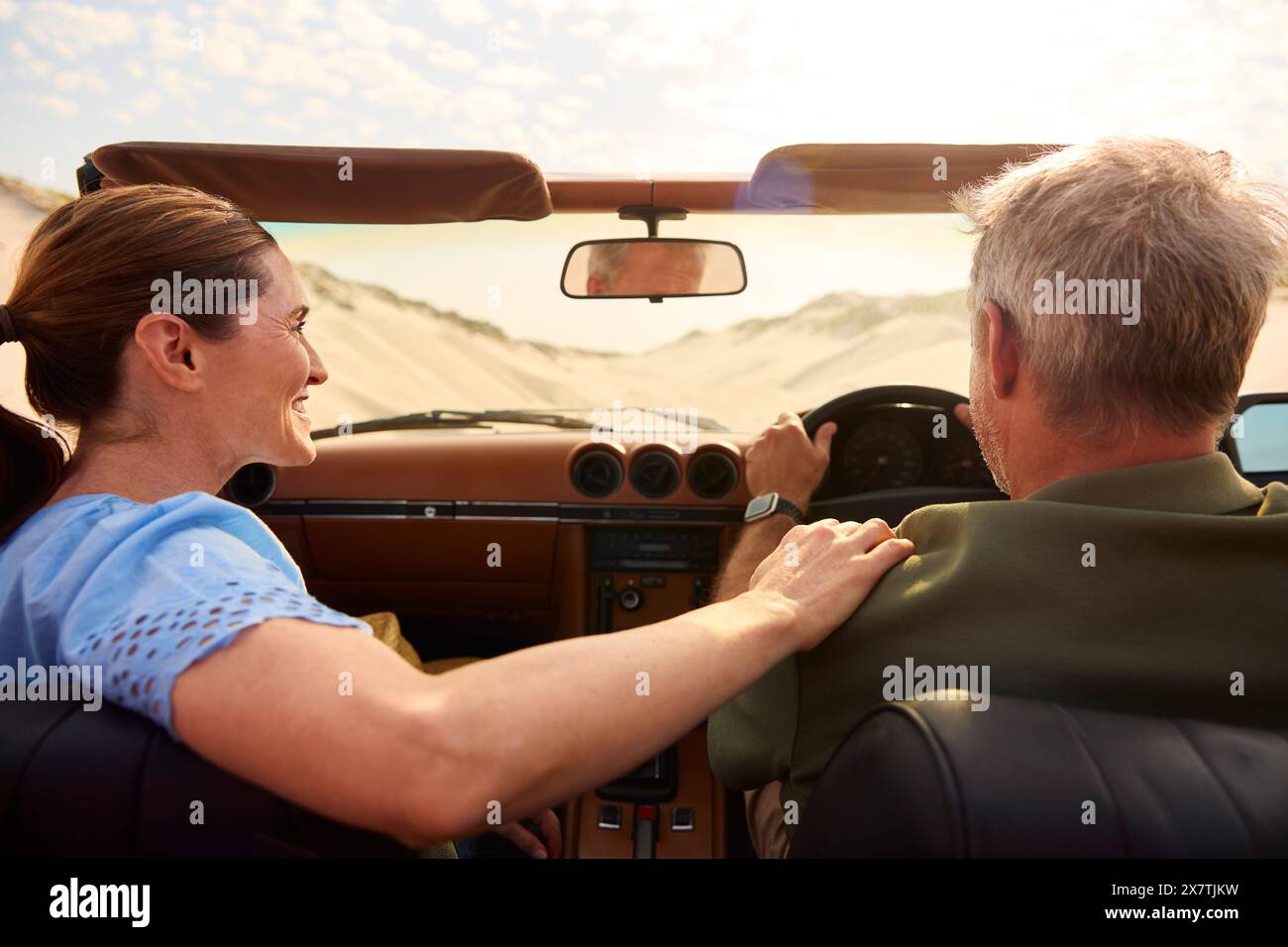 Retired Senior Couple On Vacation Driving In Classic Sports Car On Road ...