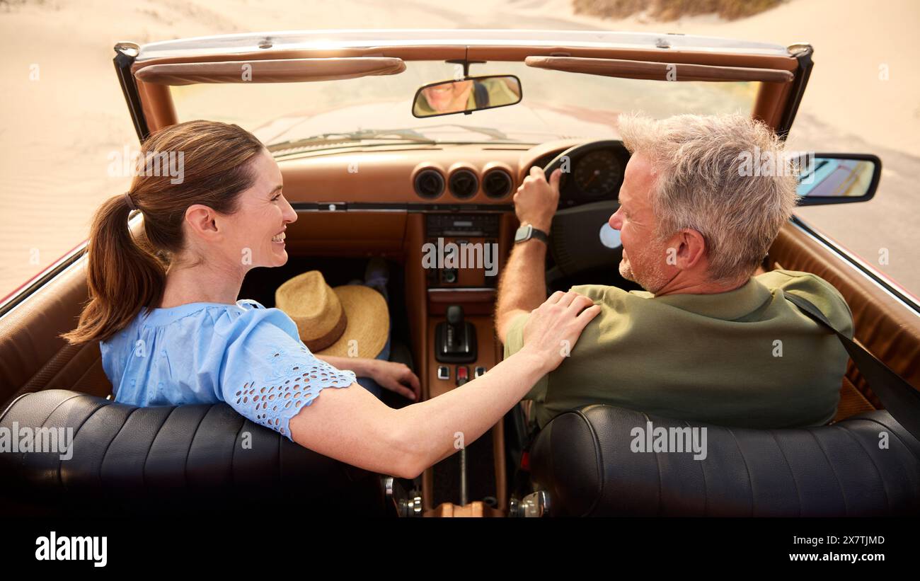 Retired Senior Couple On Vacation Driving In Classic Sports Car On Road ...