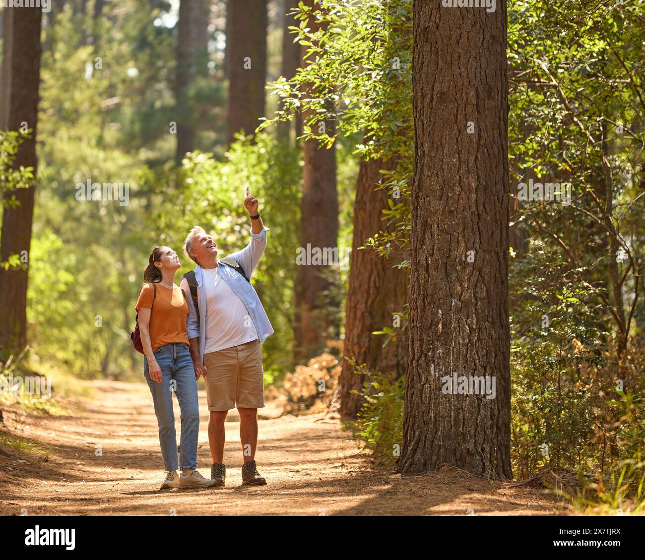 Senior Man Pointing As Retired Couple Hold Hands And Hike Along Trail ...
