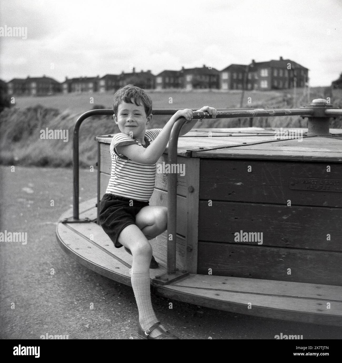 1960s, historical, holding on to the one of the metal handrails, a boy ...