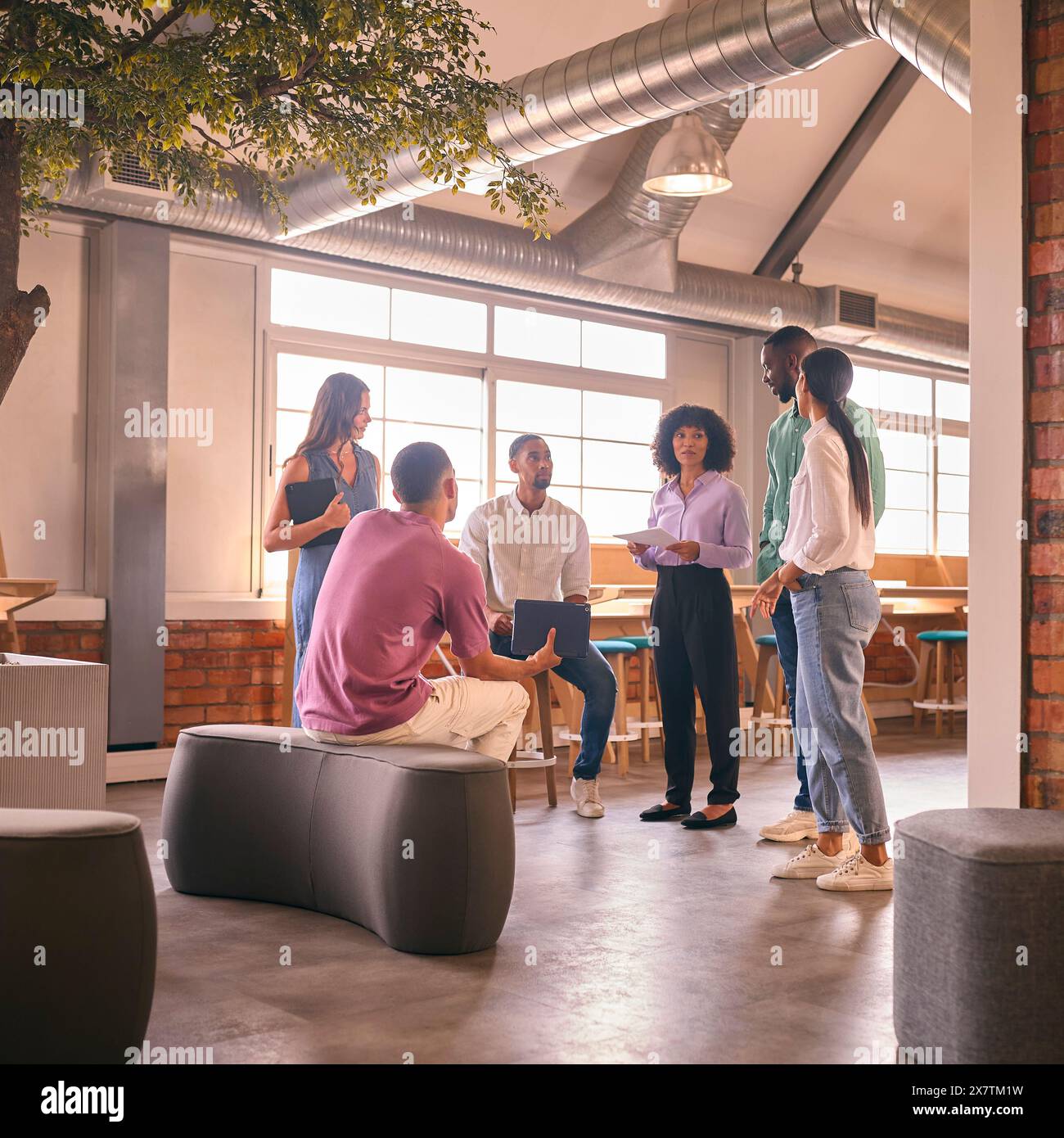 Multi-Cultural Business Team Having Informal Meeting Standing In Modern ...