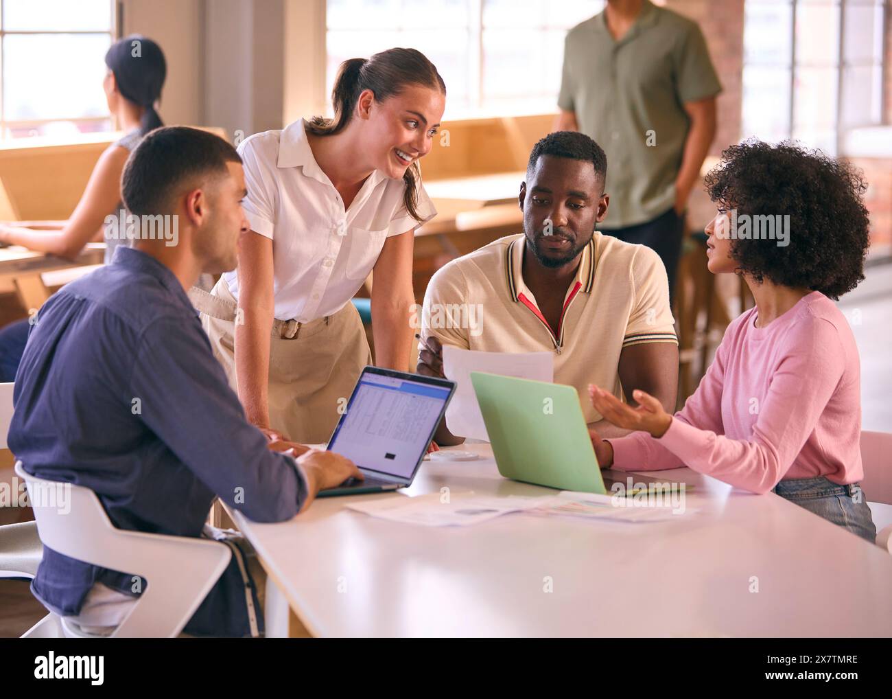 Multi-Cultural Business Team Meeting Around Desk In Modern Open Plan ...
