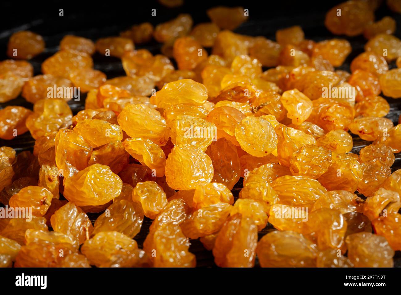 yellow raisins macro on black wood background Stock Photo - Alamy